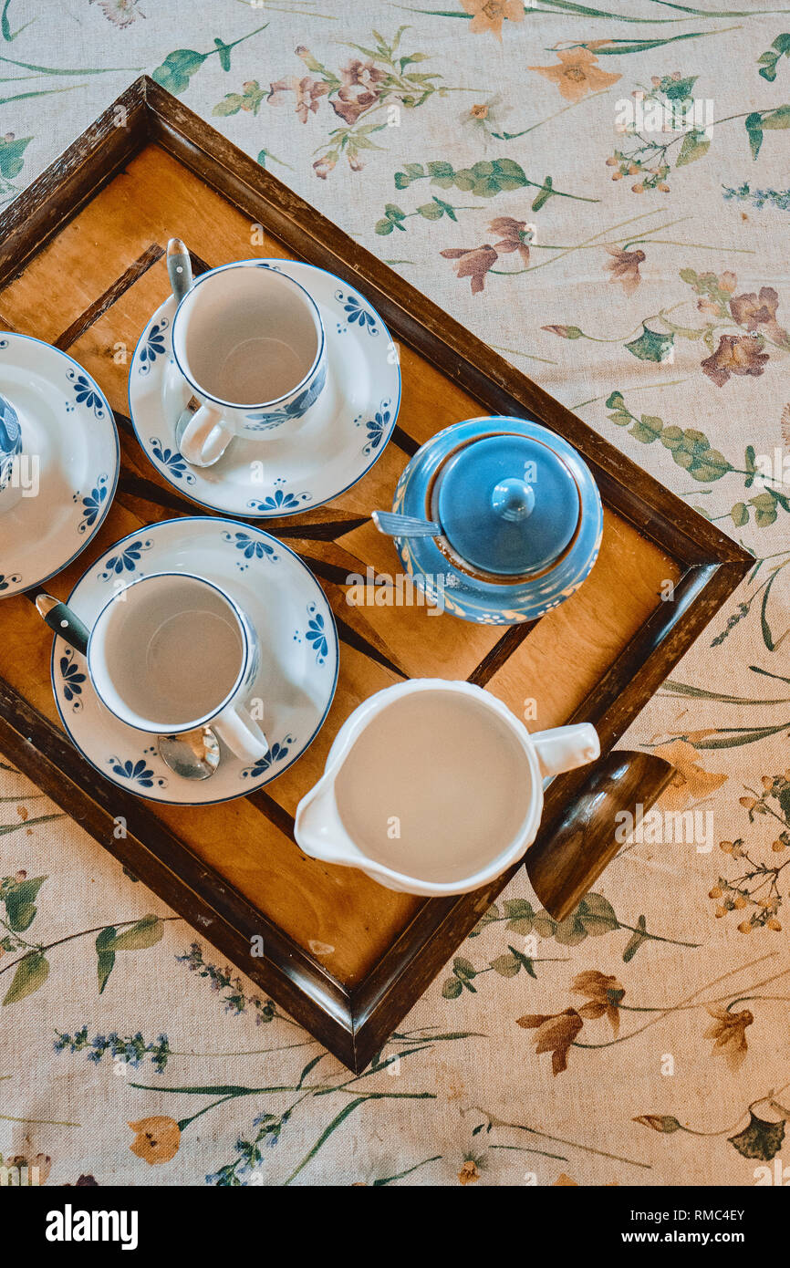 A vintage table cloth with a tea set on a wooden tray interior detail ...