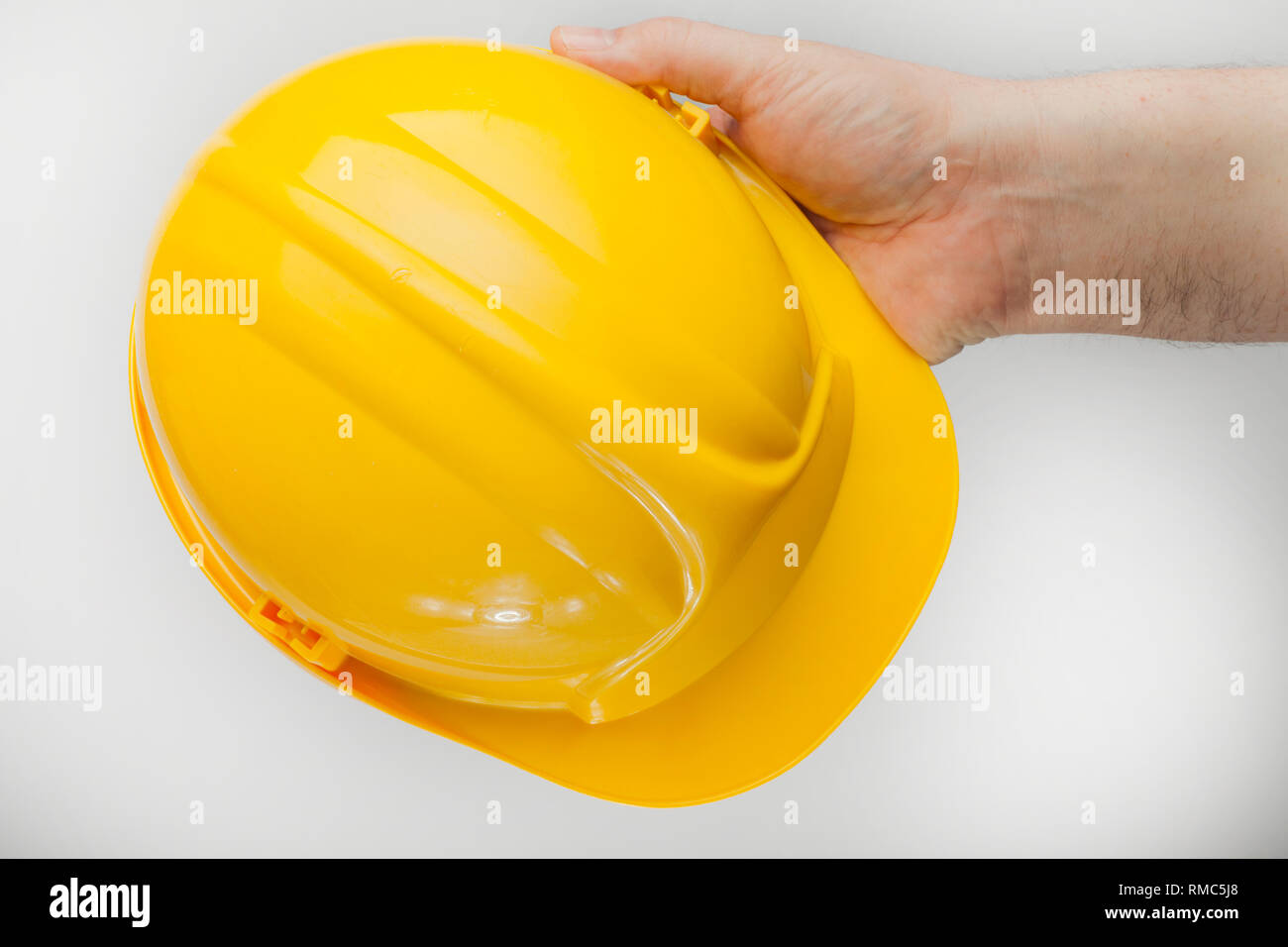 Male hand holding a safety helmet, isolated on the white background ...