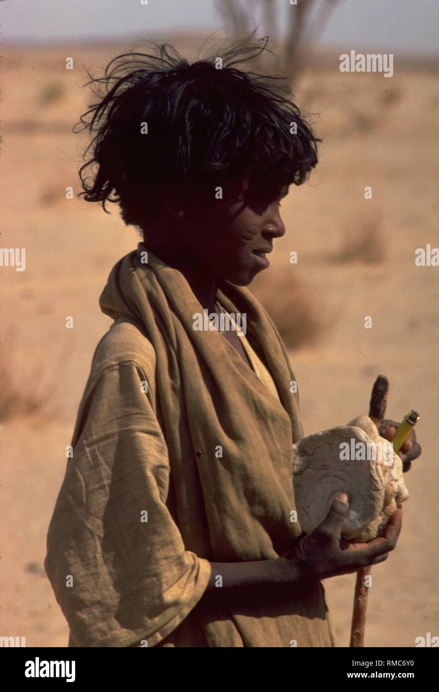 Sudanese boy with flatbread and lighter in the Nubian desert Stock ...