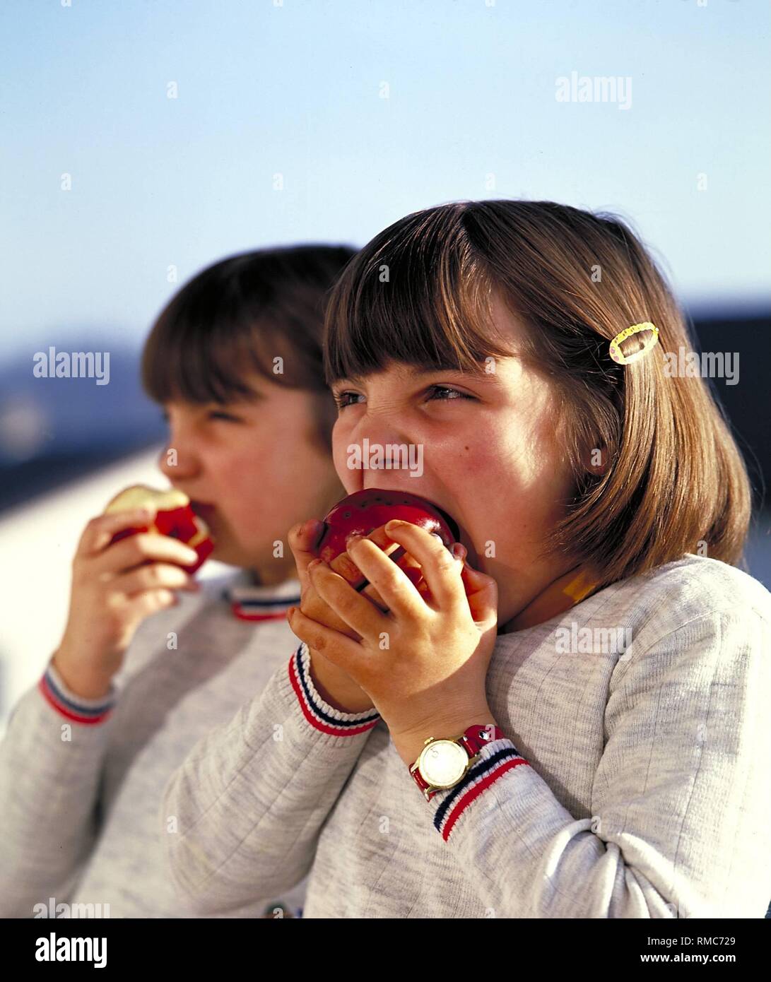 Twins eating apples Stock Photo - Alamy