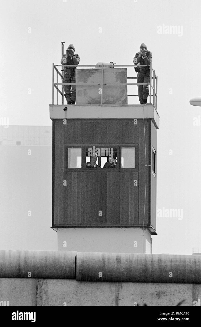 East German border guards watch an event in West Berlin on the ...