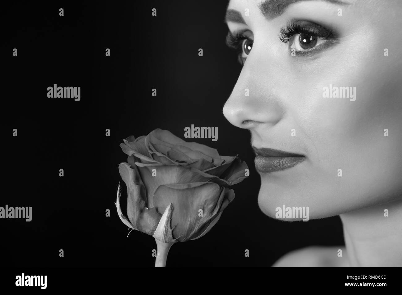 Woman sniff rose, black background copy space. Lady with makeup enjoy ...