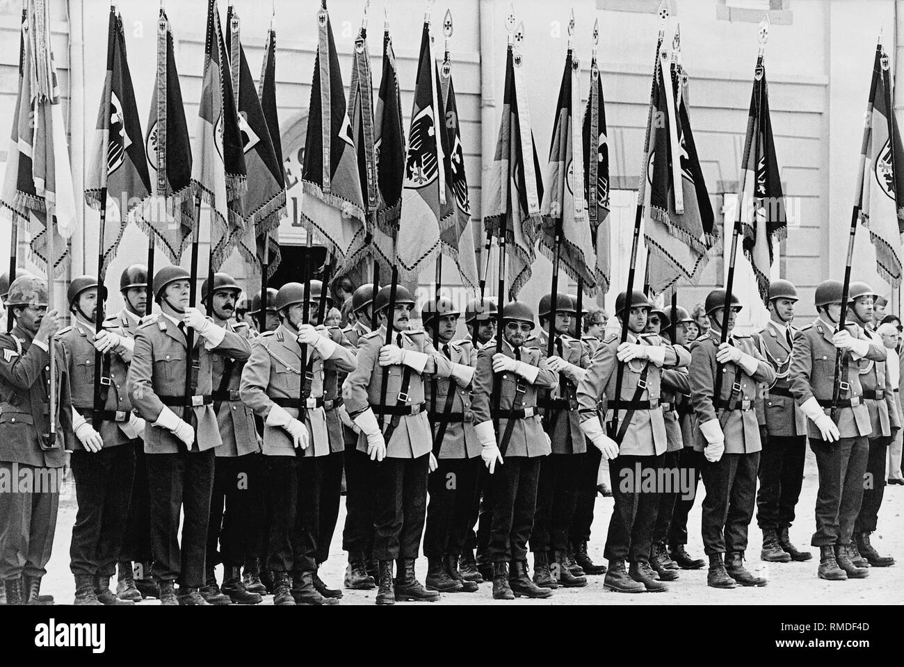 Flag bearers lined up with troop flags of the Bundeswehr at a roll call ...