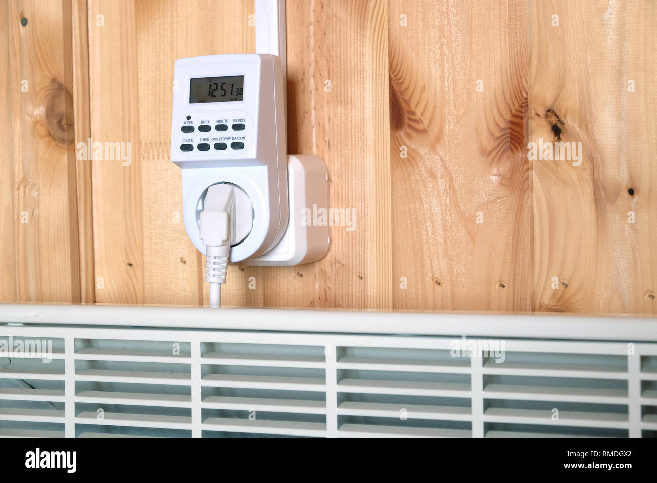 Working white electric convector heater plugged to timer power socket ...