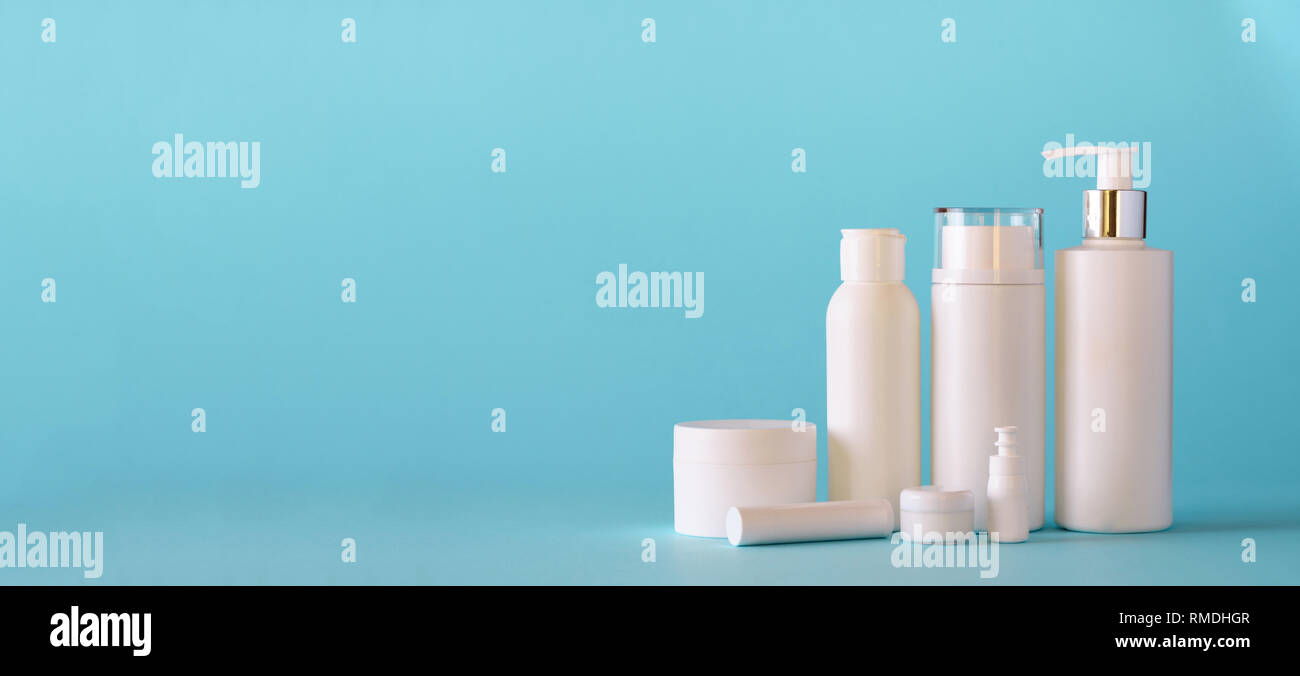 White cosmetic tubes on blue background with copy space. Skin care ...