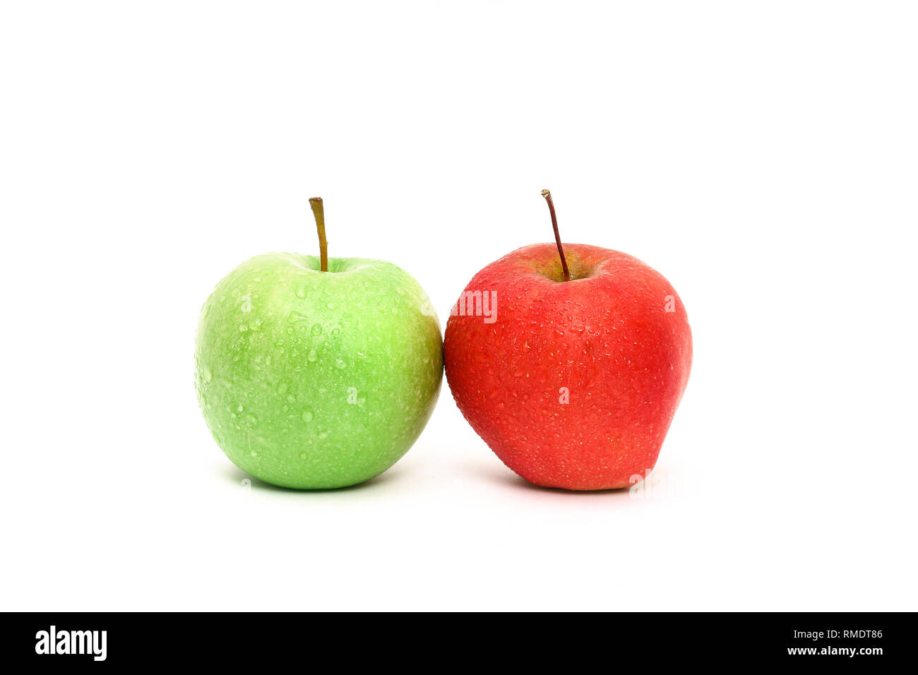 A pair of fresh washed apples, one green and one red, touching ...