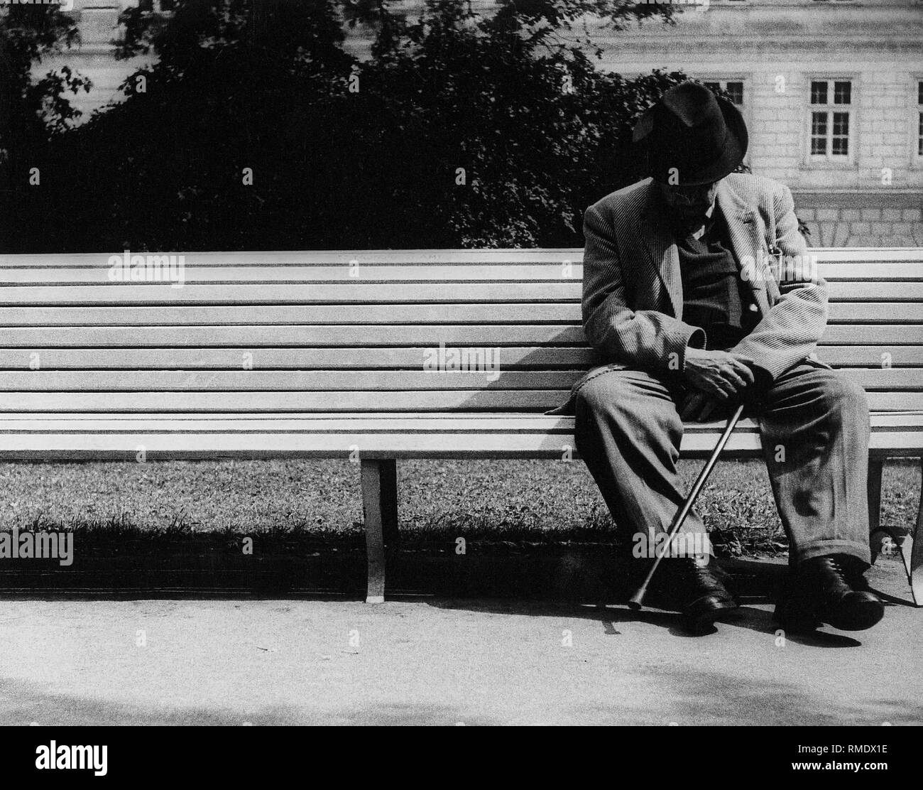 Senior man on a bench in front of the retirement home Stock Photo - Alamy