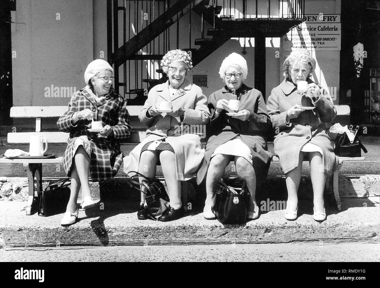 Four old British ladies sit on a bench and drink tea Stock Photo - Alamy