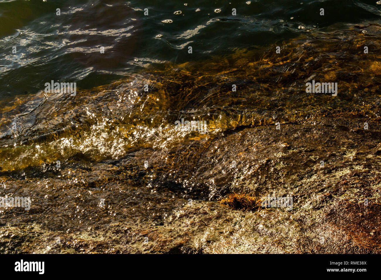 Water lapping onto a rocky lake-shore Stock Photo - Alamy