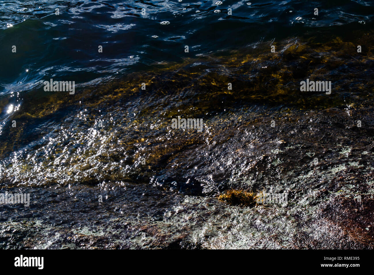 Water lapping onto a rocky lake-shore Stock Photo - Alamy