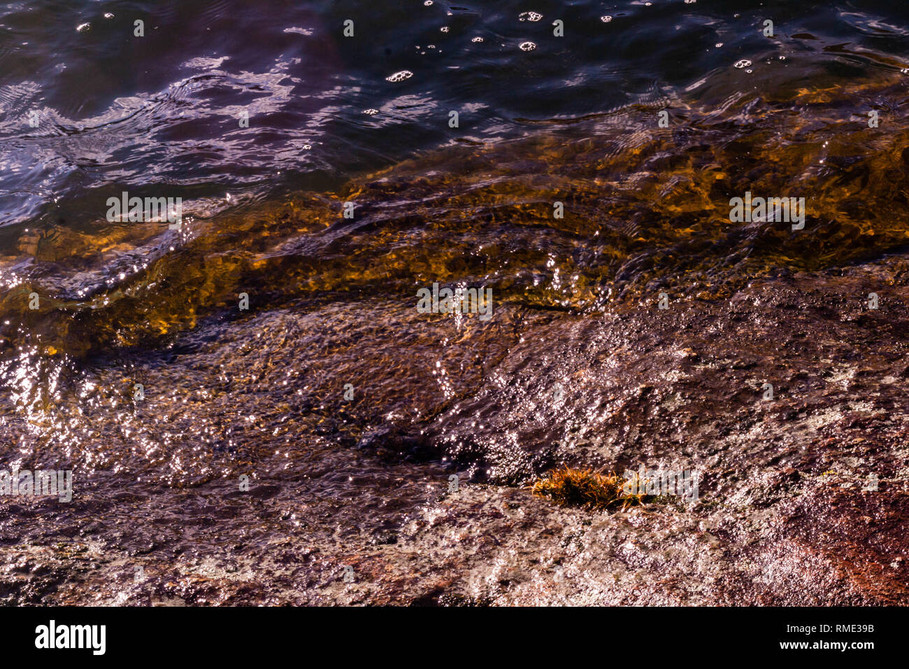 Water lapping onto a rocky lake-shore Stock Photo - Alamy