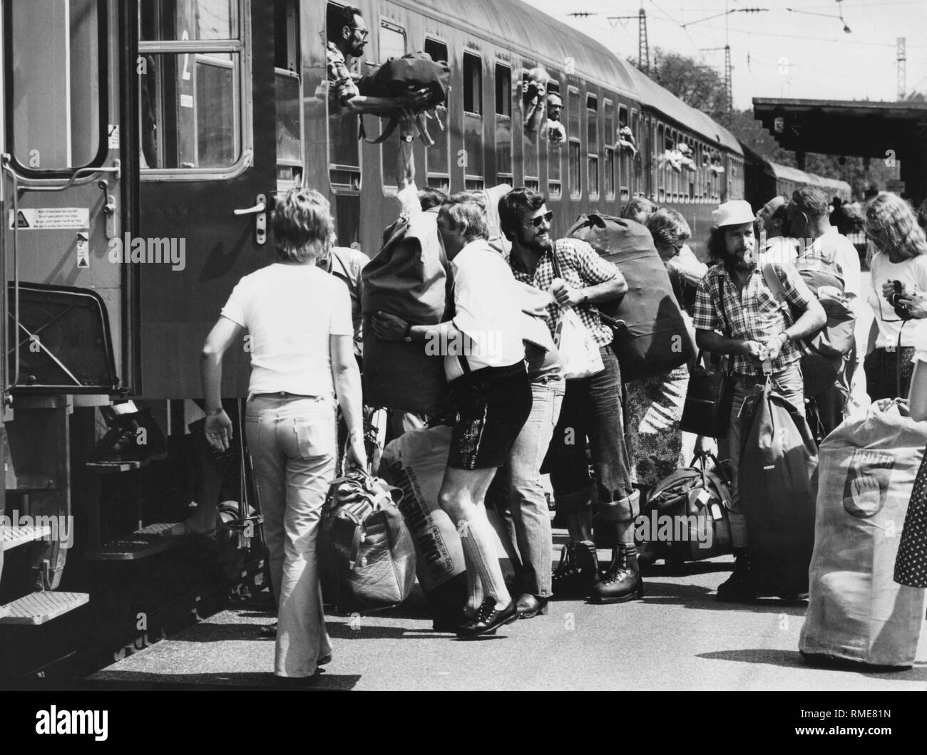 Rail passengers climb into a train Stock Photo - Alamy