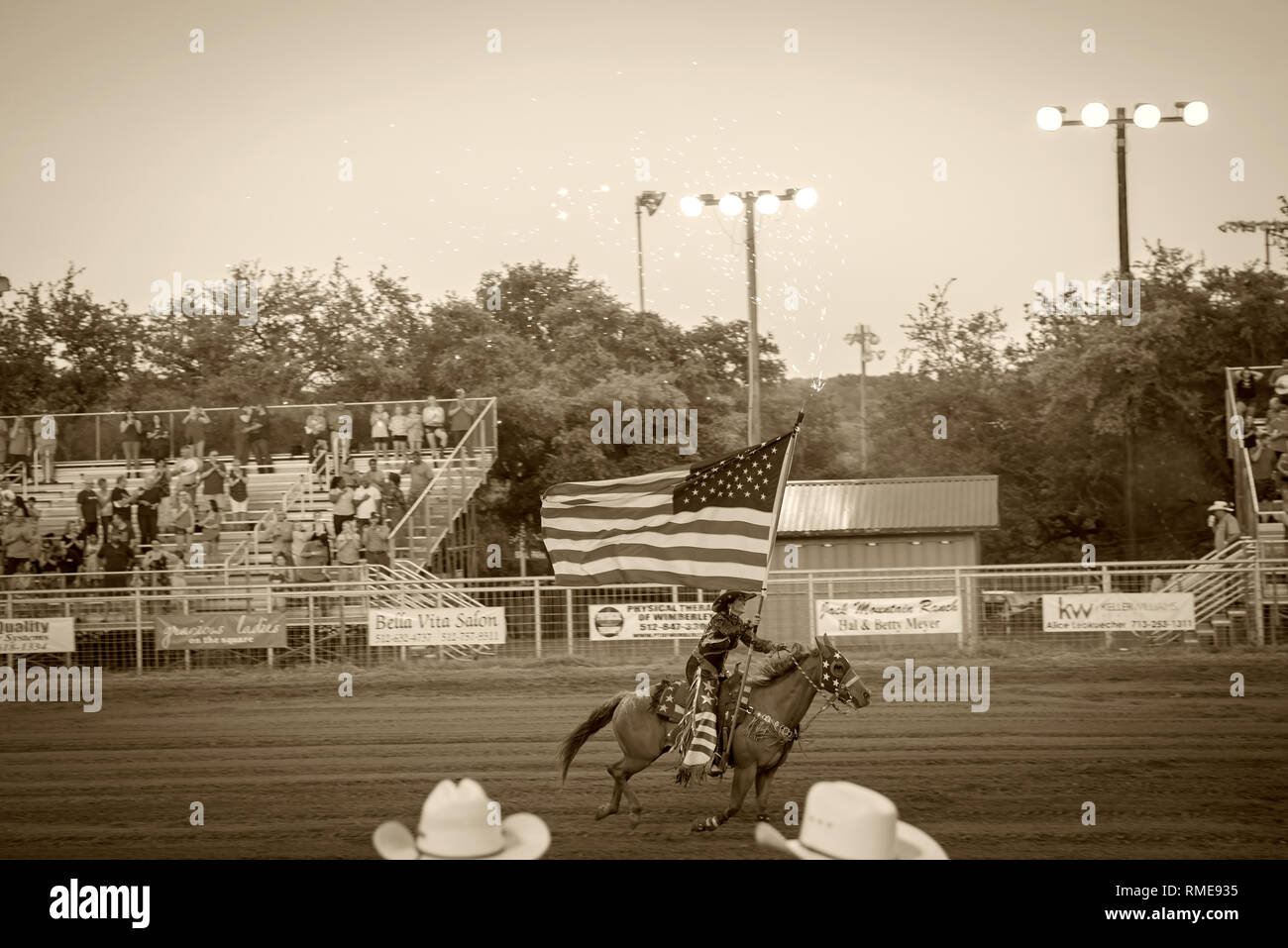 Cowgirl horseback riding with American flag during rodeo Stock Photo ...