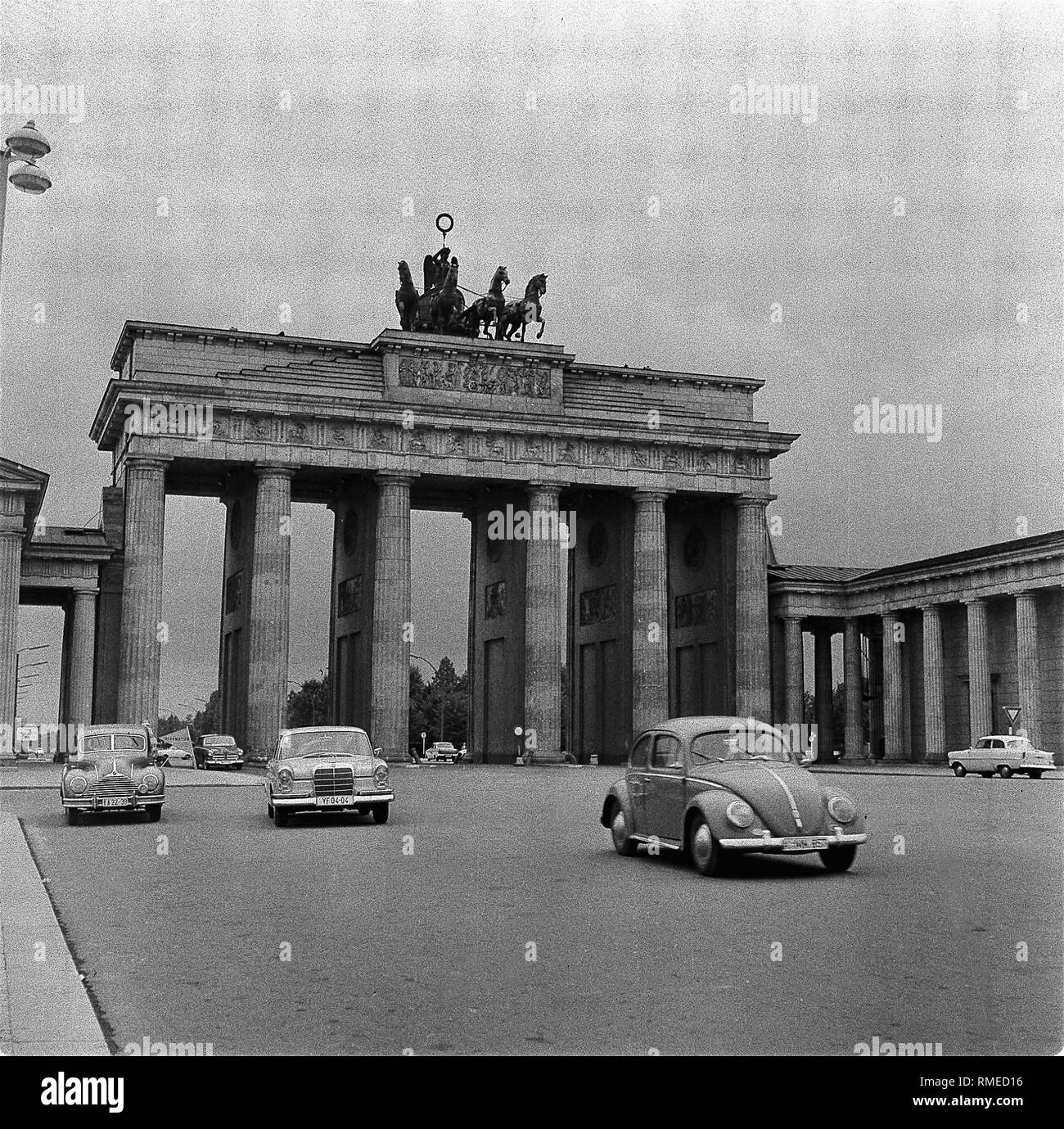 The Brandenburg Gate in front of the wall with cars from the west Stock ...