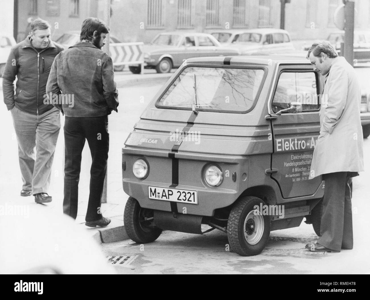 Passers-by look at a "Delcar" electric car. The "Delcar" was 35 to 40 ...