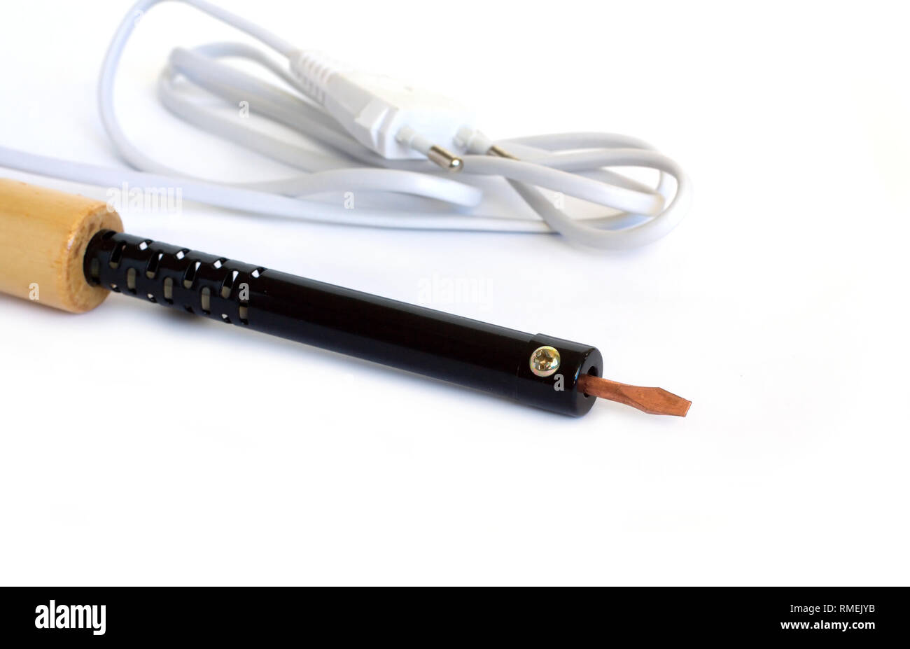 Electric soldering iron with a wooden handle and a white wire with a ...