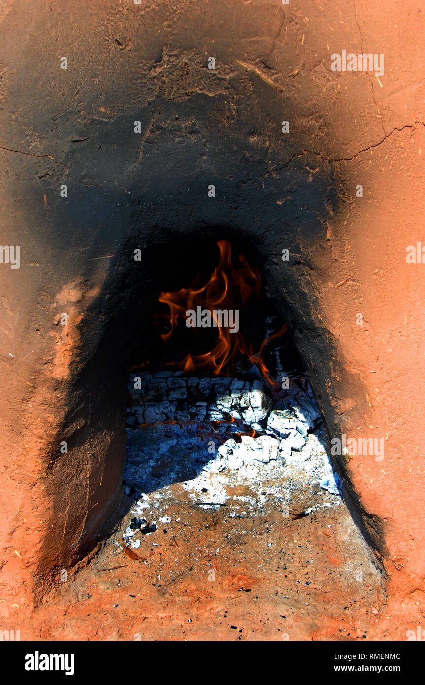 Native American kiva oven, called a horno, burns brightly. Oven has ...