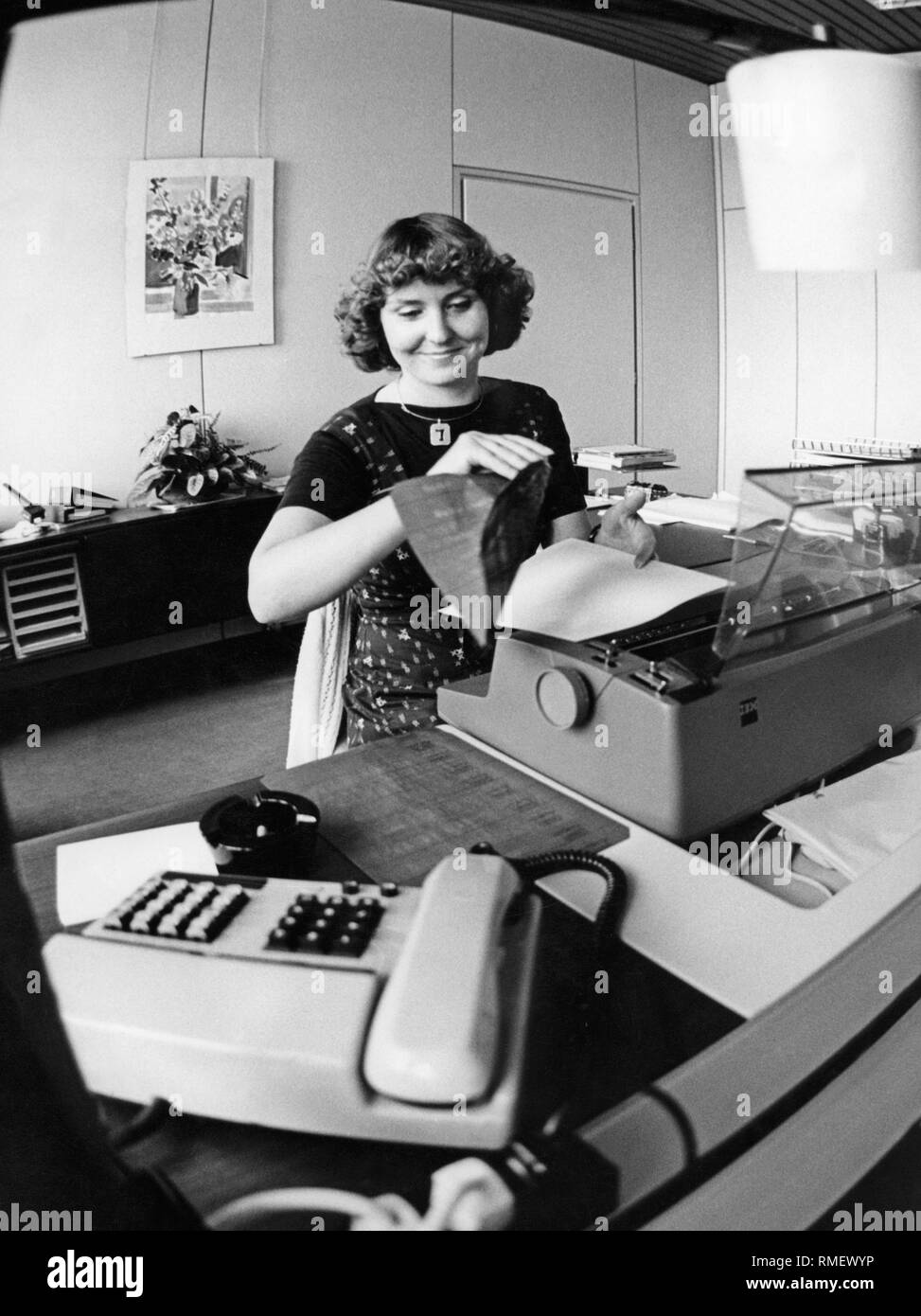 Secretary at the typewriter in the office. She handles carbon paper ...