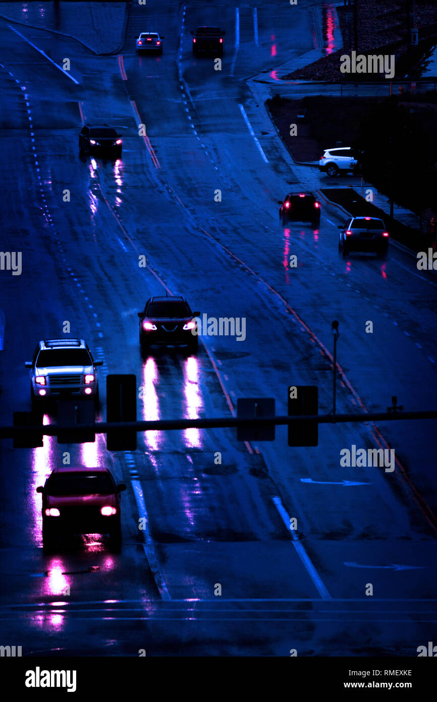 Rainstorm with cars driving in storm on roadway street lamps headlights ...