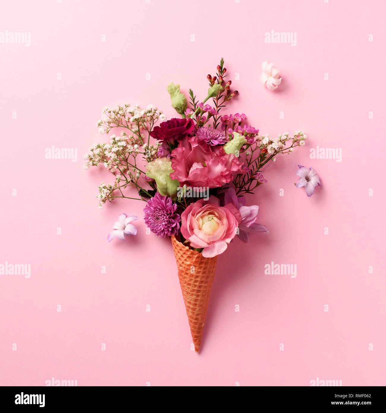 Summer minimal concept. Ice cream cone with pink flowers and leaves on ...