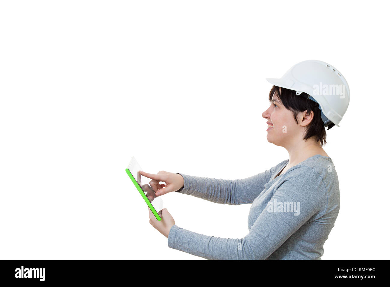 Side view of smiling young woman engineer wearing protective helmet ...