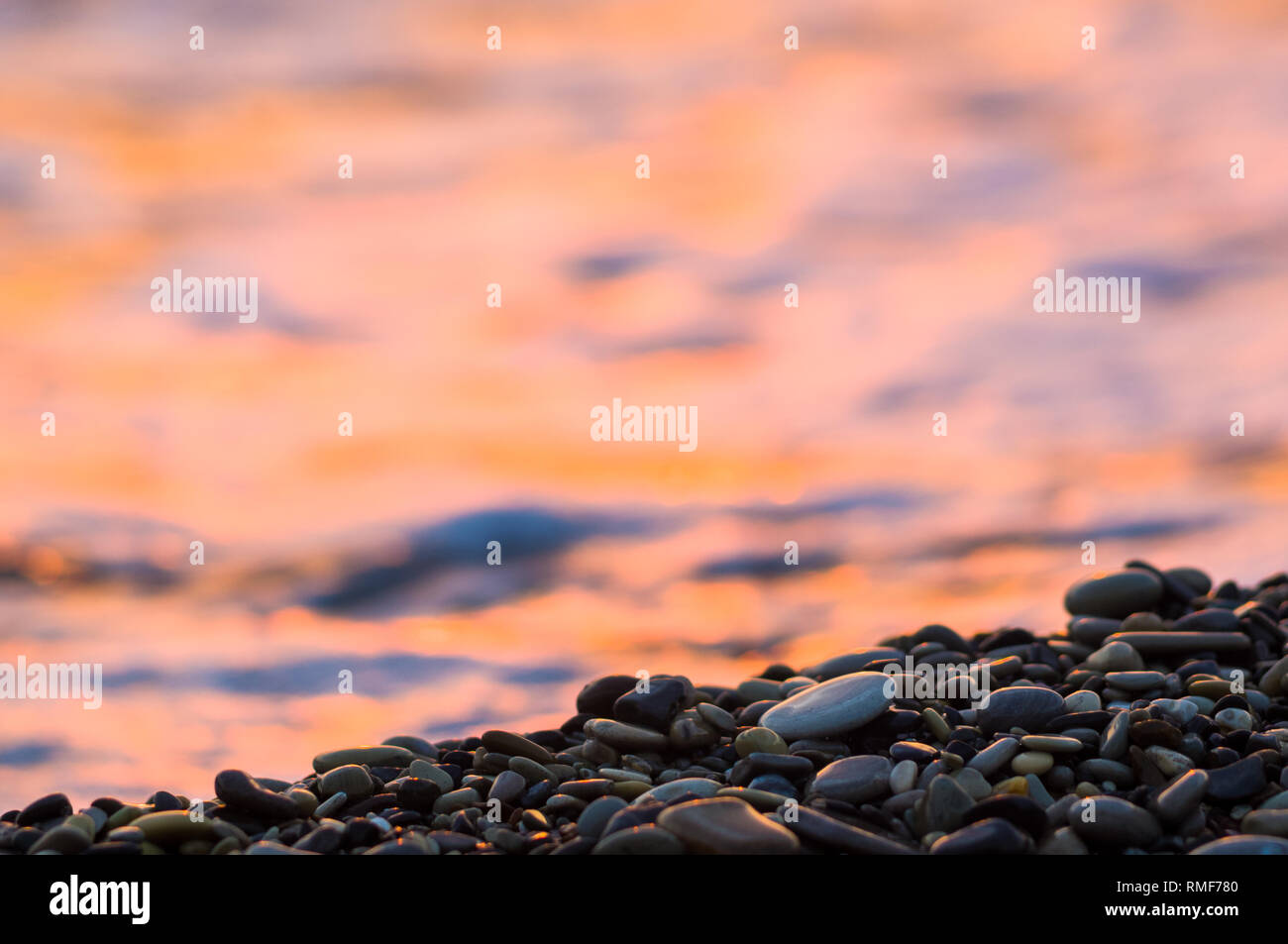 pebble stones on the sea beach on a warm summer evening at sunset, the ...