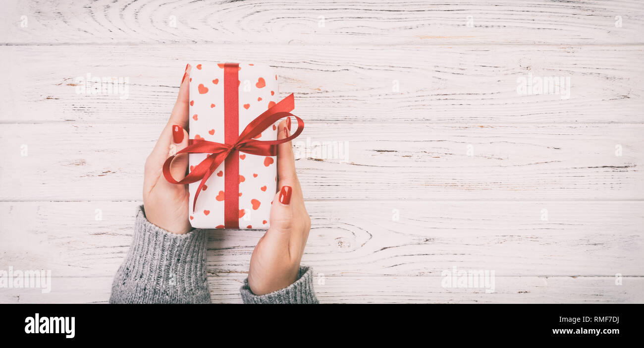 Woman hands give wrapped valentine or other holiday handmade present in ...