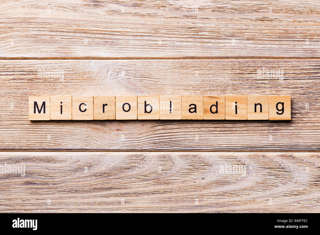 Microblading word written on wood block. Microblading text on wooden ...