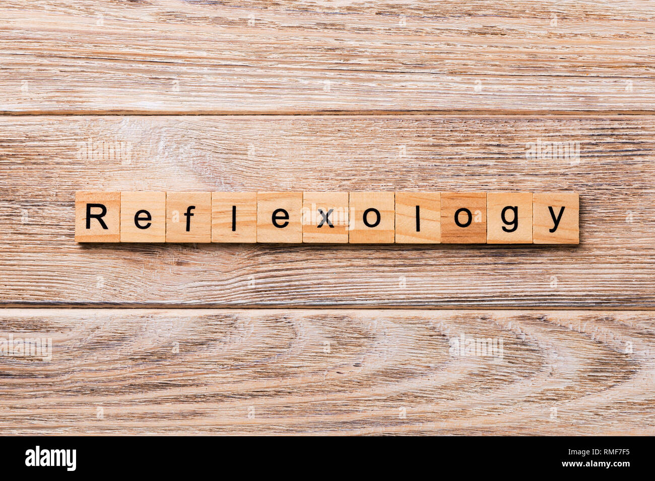reflexology word written on wood block. reflexology text on wooden ...