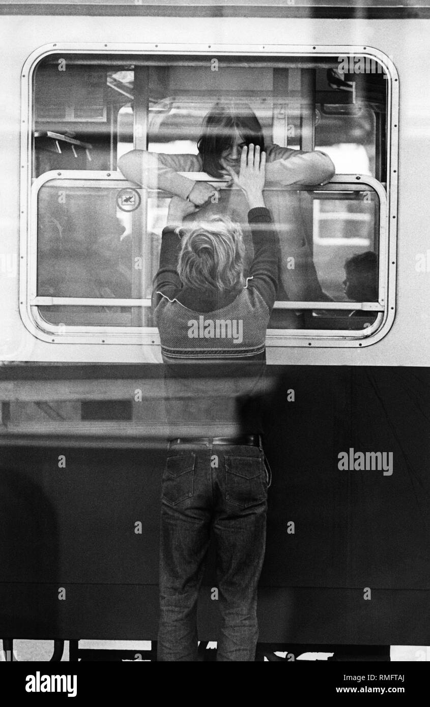 A passenger says goodbye through the window of a passenger train Stock ...