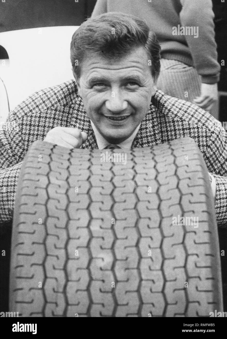 Racing driver Hans Herrmann with a wheel Stock Photo - Alamy