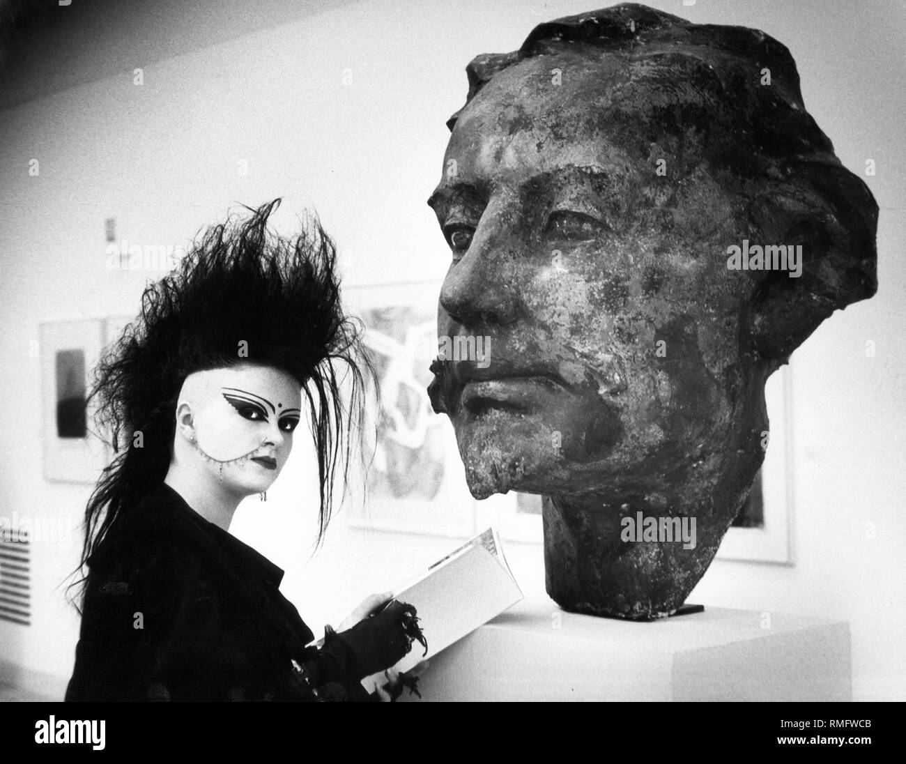Punk in an art-exhibition in front of a head in Munich Stock Photo - Alamy
