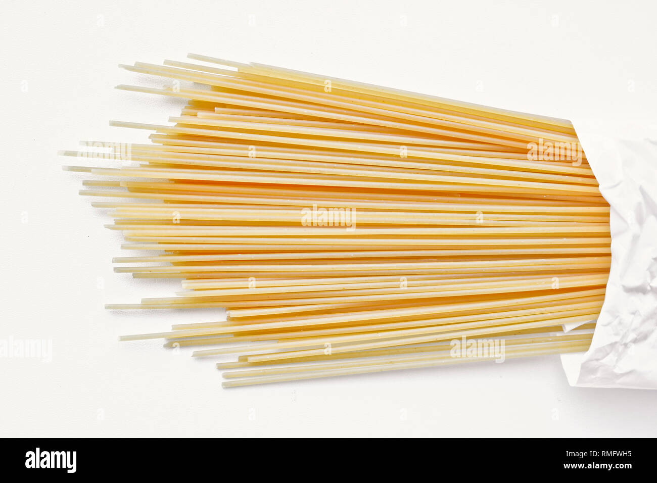 Yellow long spaghetti on a light background. Thin pasta arranged in ...