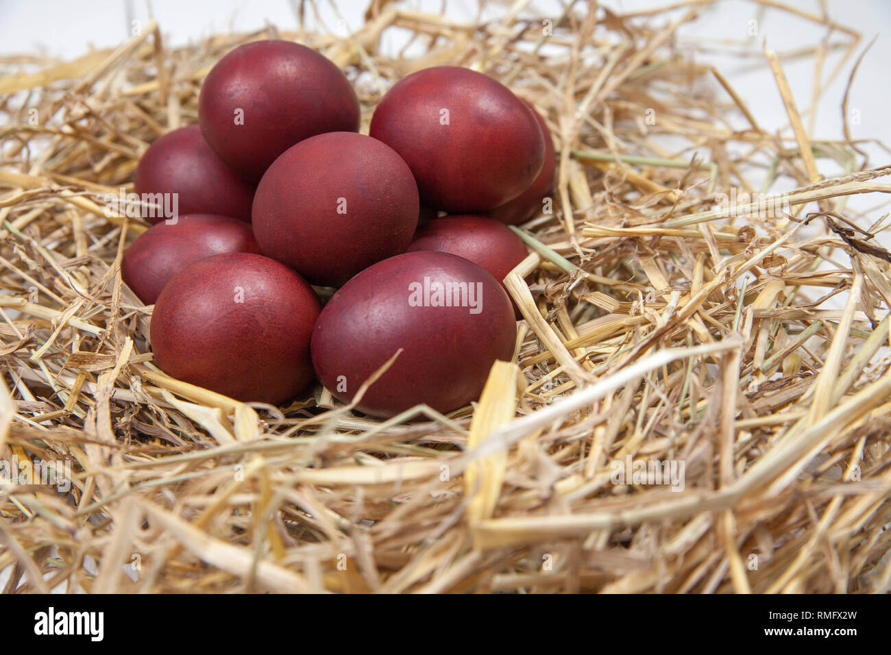 Red Easter eggs in a straw nest Stock Photo - Alamy
