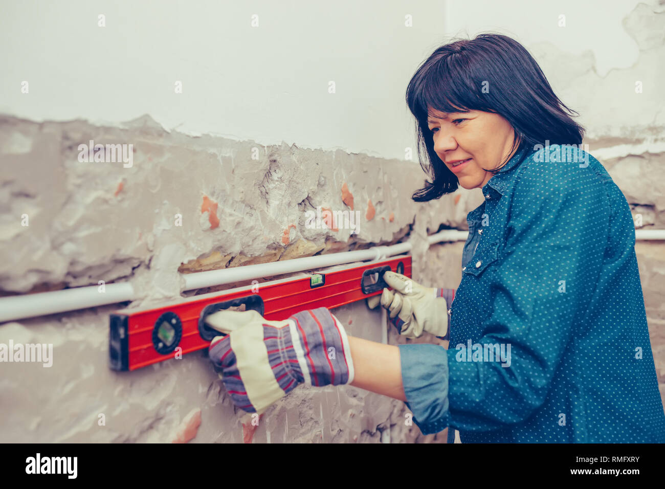 Clever woman repairing her bathroom sink pipe with positive attitude ...