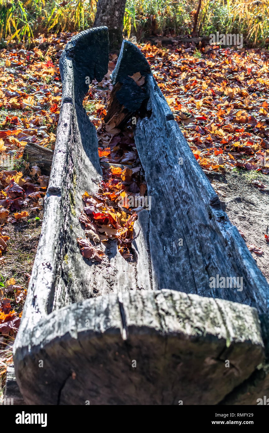 Old wooden boat sprinkled with orange autumn leaves in a reconstructed ...