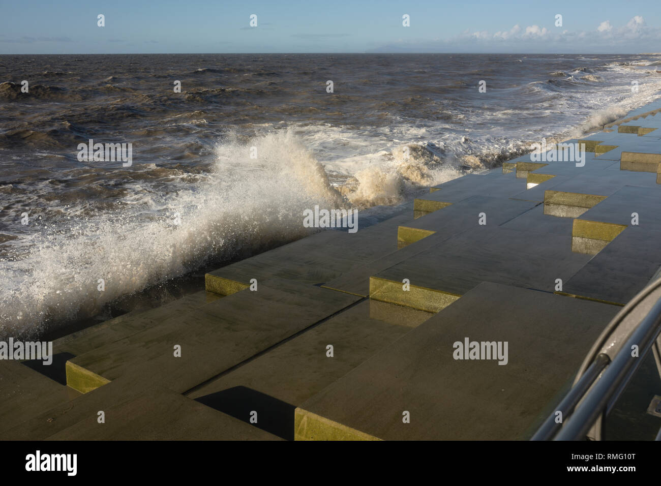 Wave overtopping concrete wavebreaker units in rough sea during stormy ...
