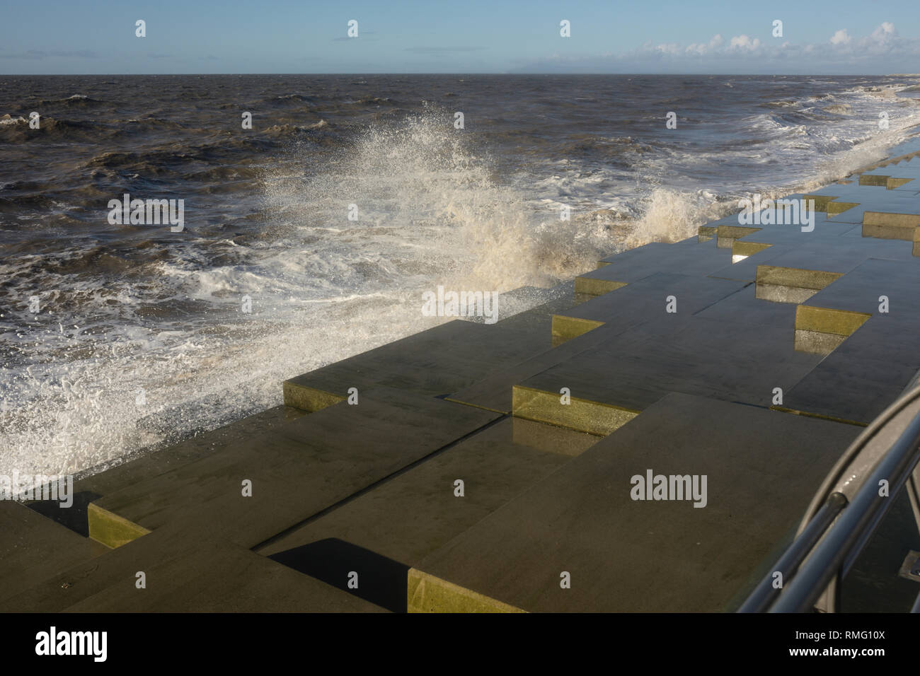 Wave overtopping concrete wavebreaker units in rough sea during stormy ...