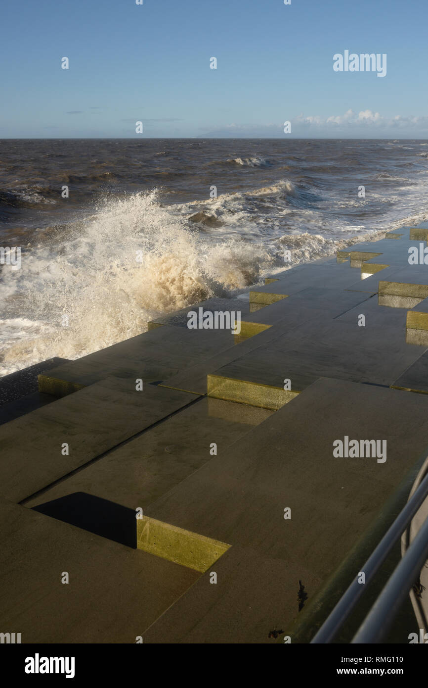 Wave overtopping concrete wavebreaker units in rough sea during stormy ...