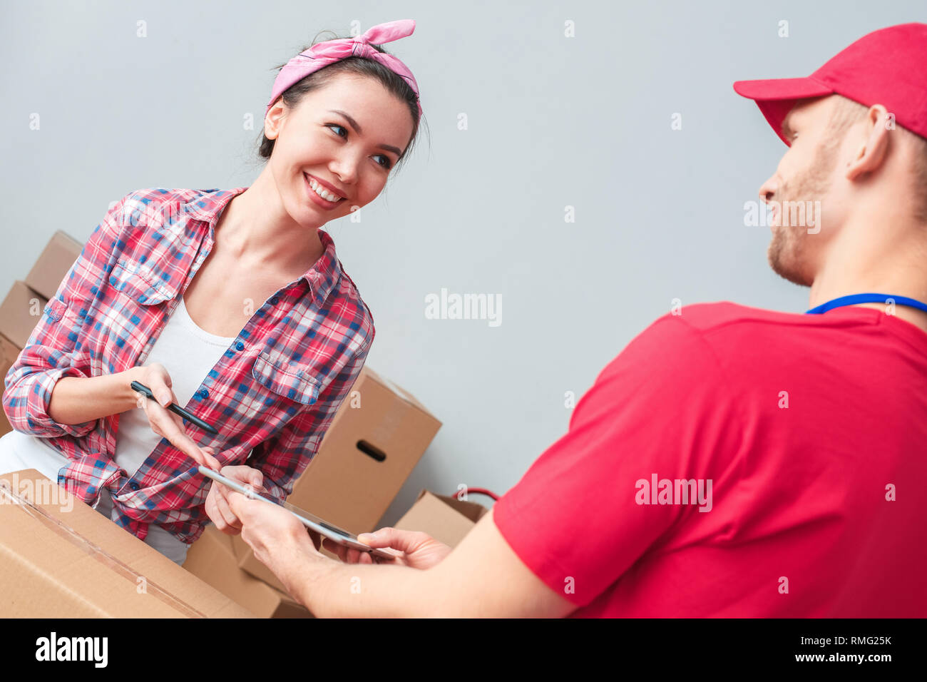 Young woman moving to new place standing siging delivery form online on ...