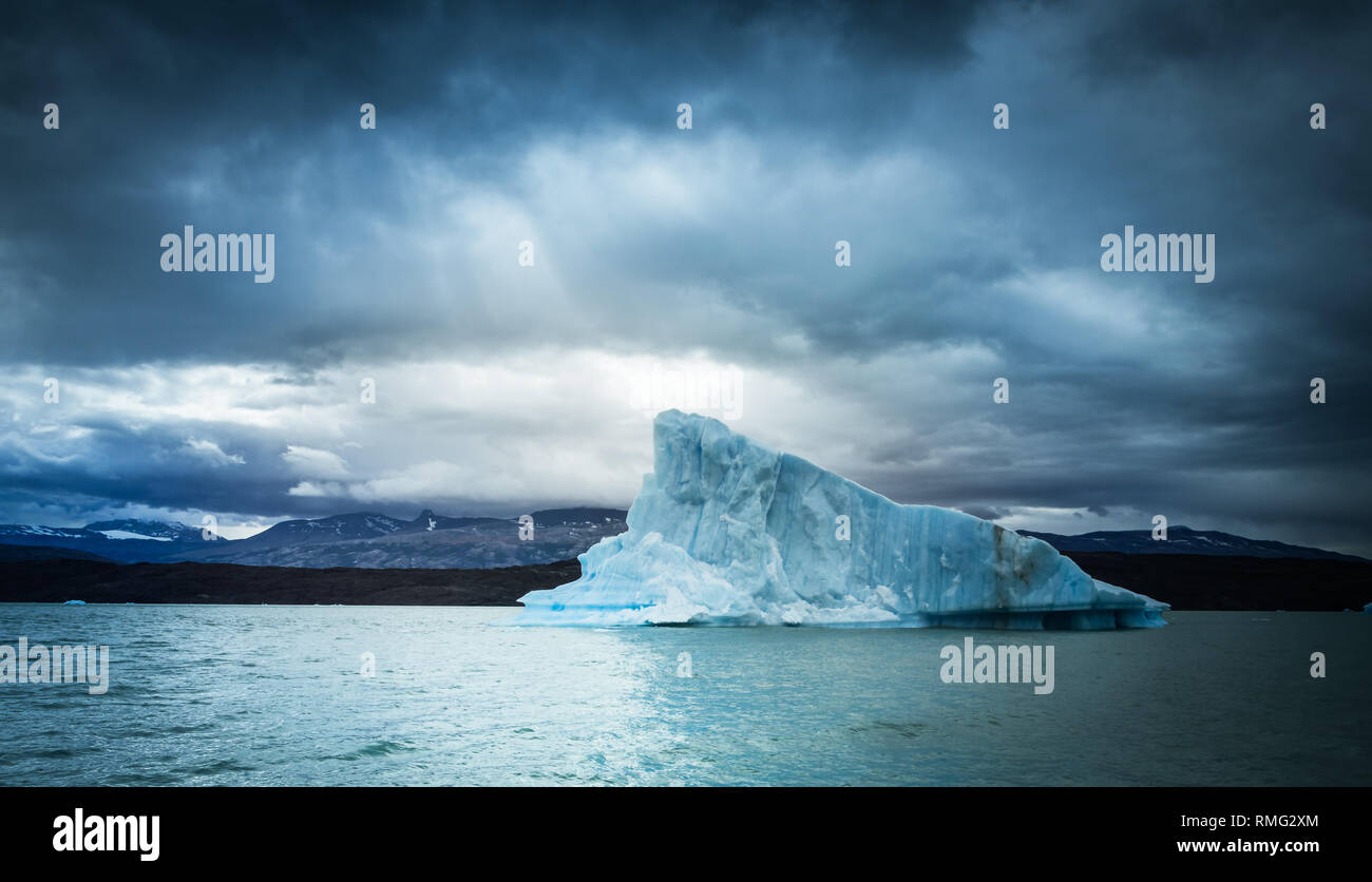 Fantastic view of huge cold iceberg against gray cloudy sky in ...