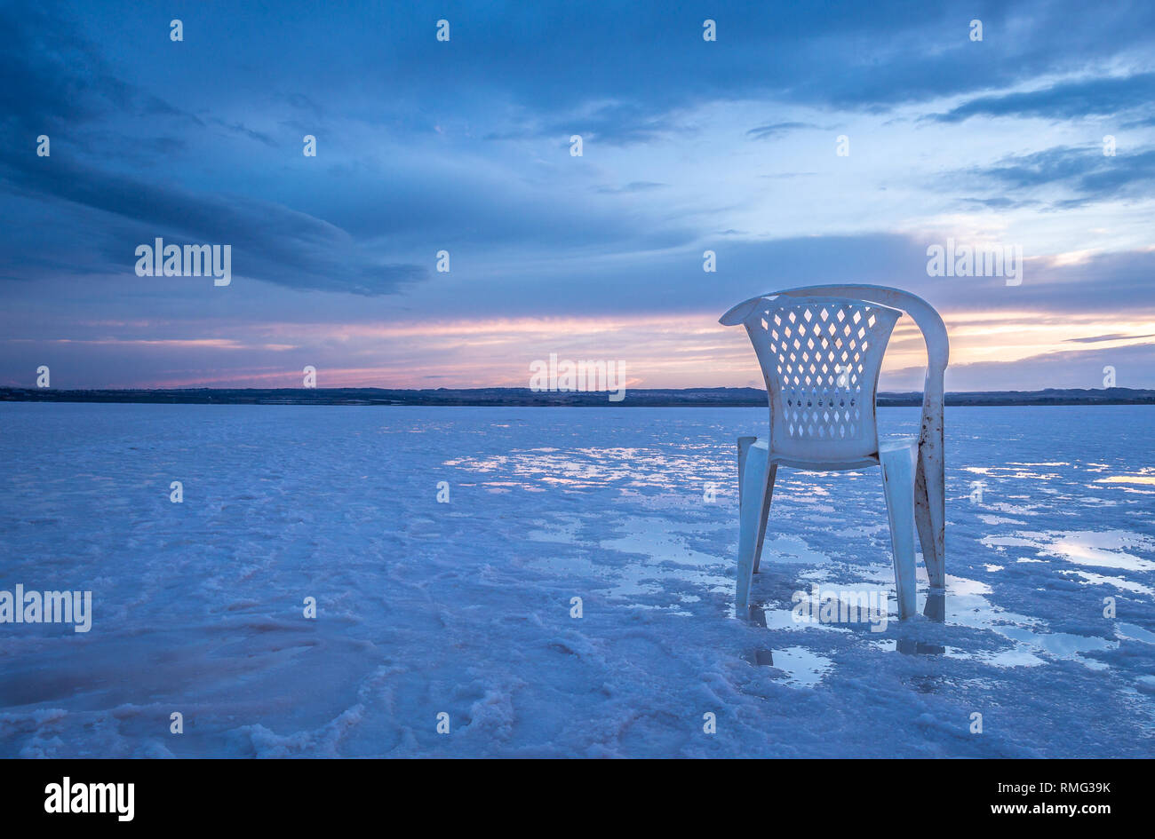 Chair on salt mine during sunset Stock Photo - Alamy
