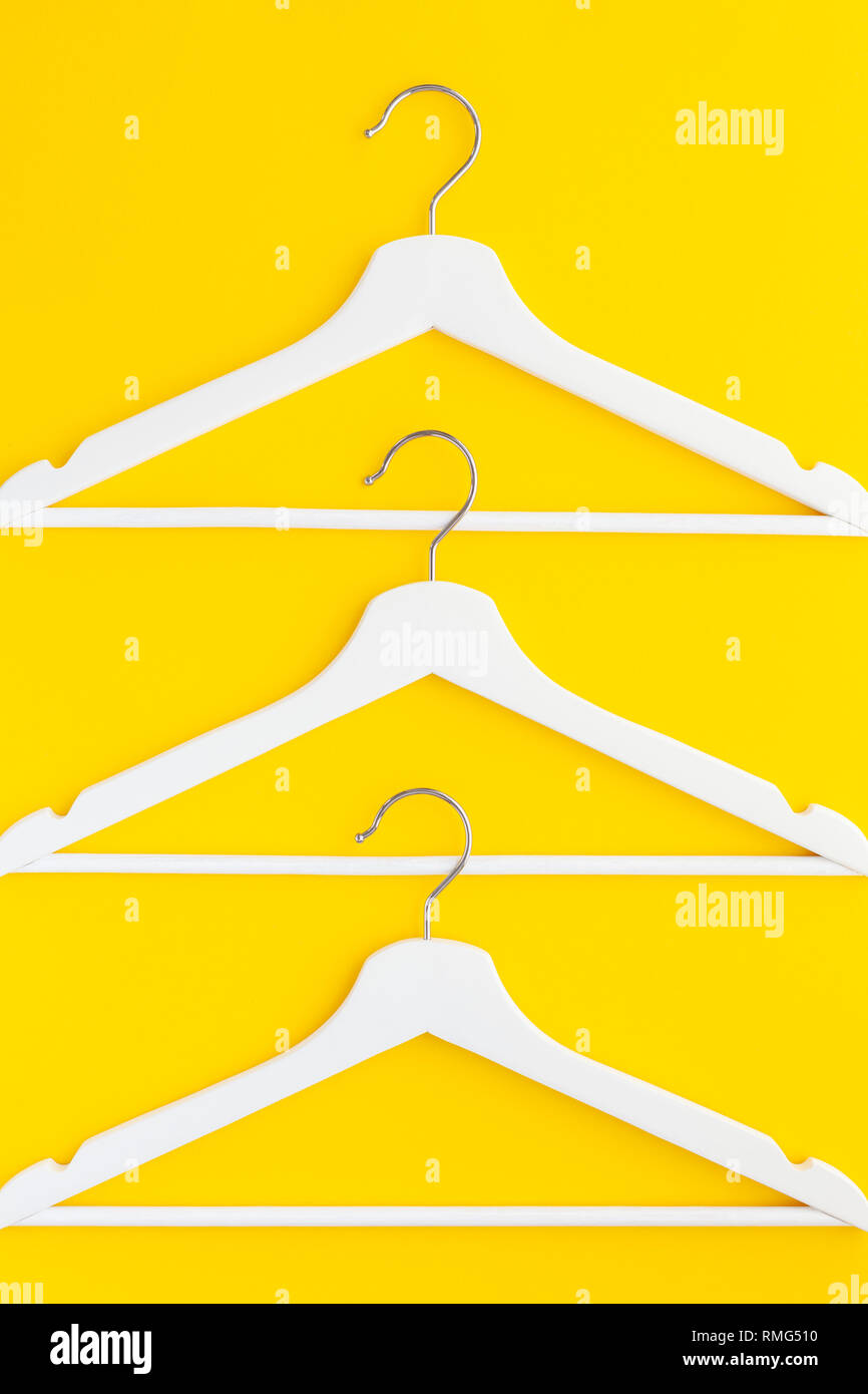 Creative top view flat lay white wooden hangers isolated bold yellow ...