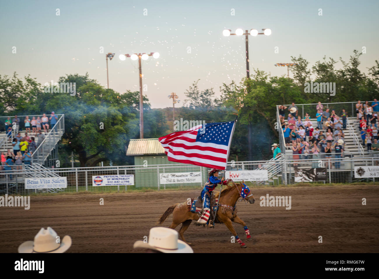 Texas cowgirl riding horseback with American flag. Opening ceremony at ...
