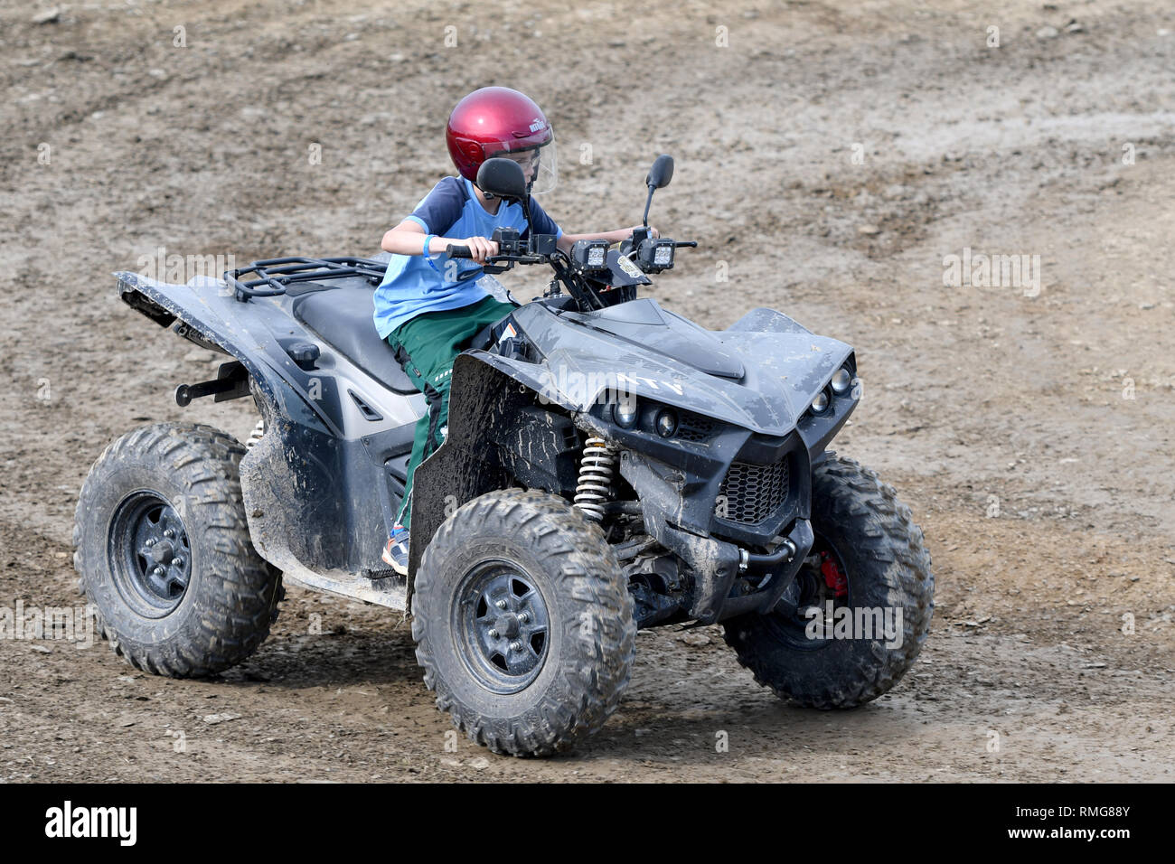 A young boy riding a quad/ATV offroad Stock Photo - Alamy