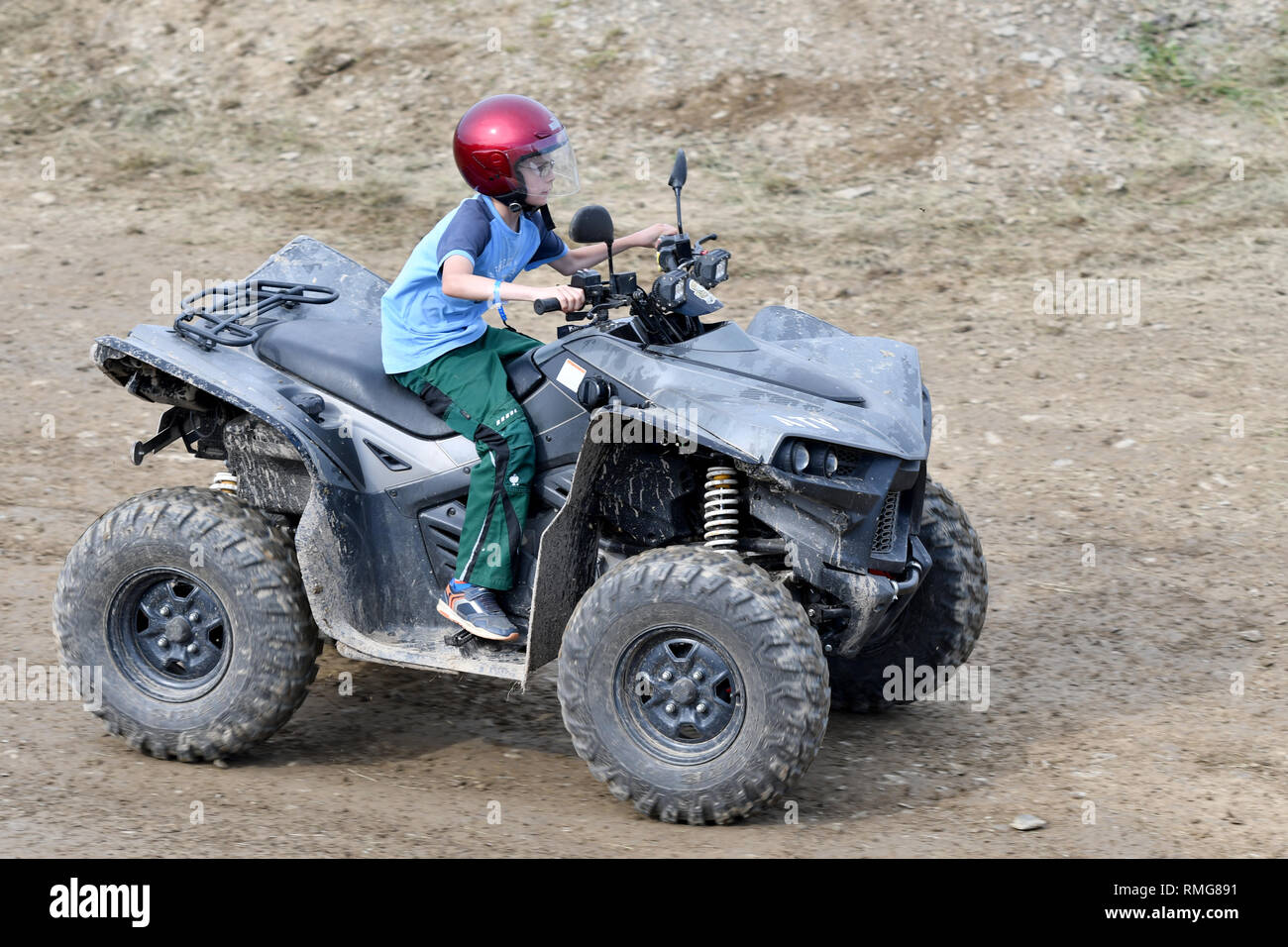 A young boy riding a quad/ATV offroad Stock Photo - Alamy