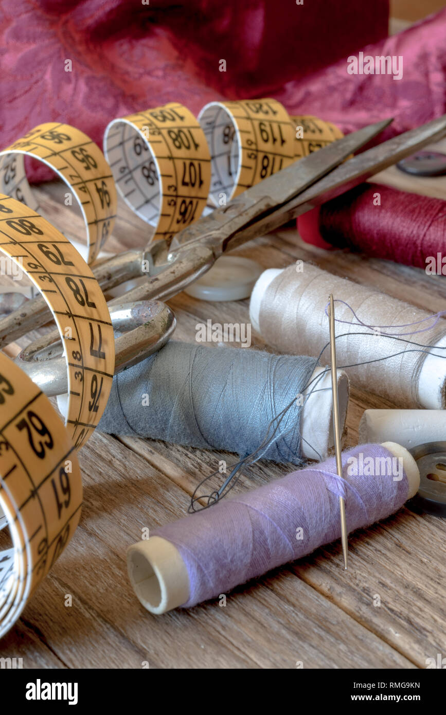 variuous dressmaking tools with, needle and thread, cotton, buttons on ...