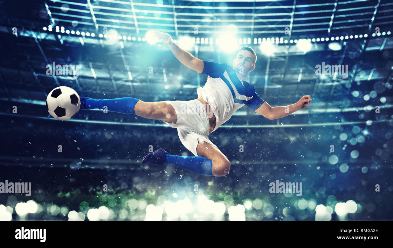 Soccer striker hits the ball with an acrobatic kick in the air at the ...