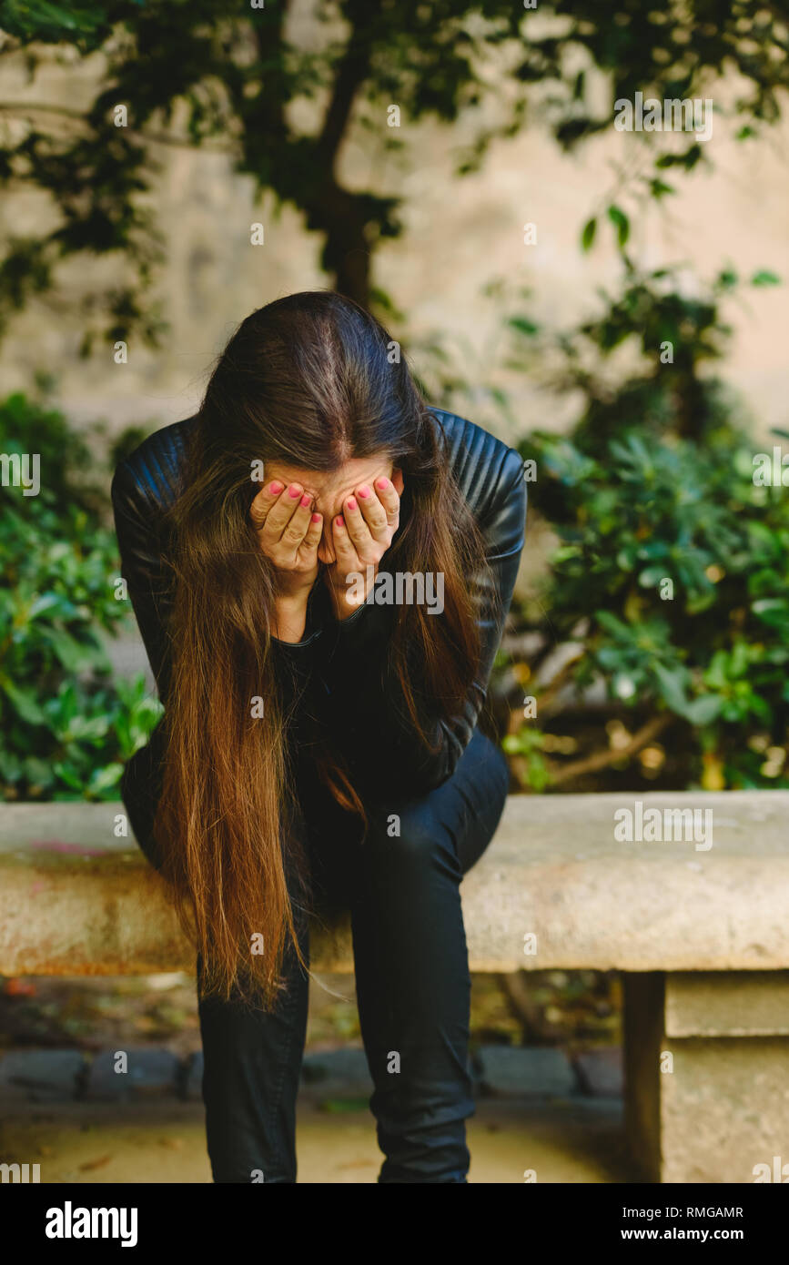 Depressed teenager crying sitting, holding head in hands feeling bad ...