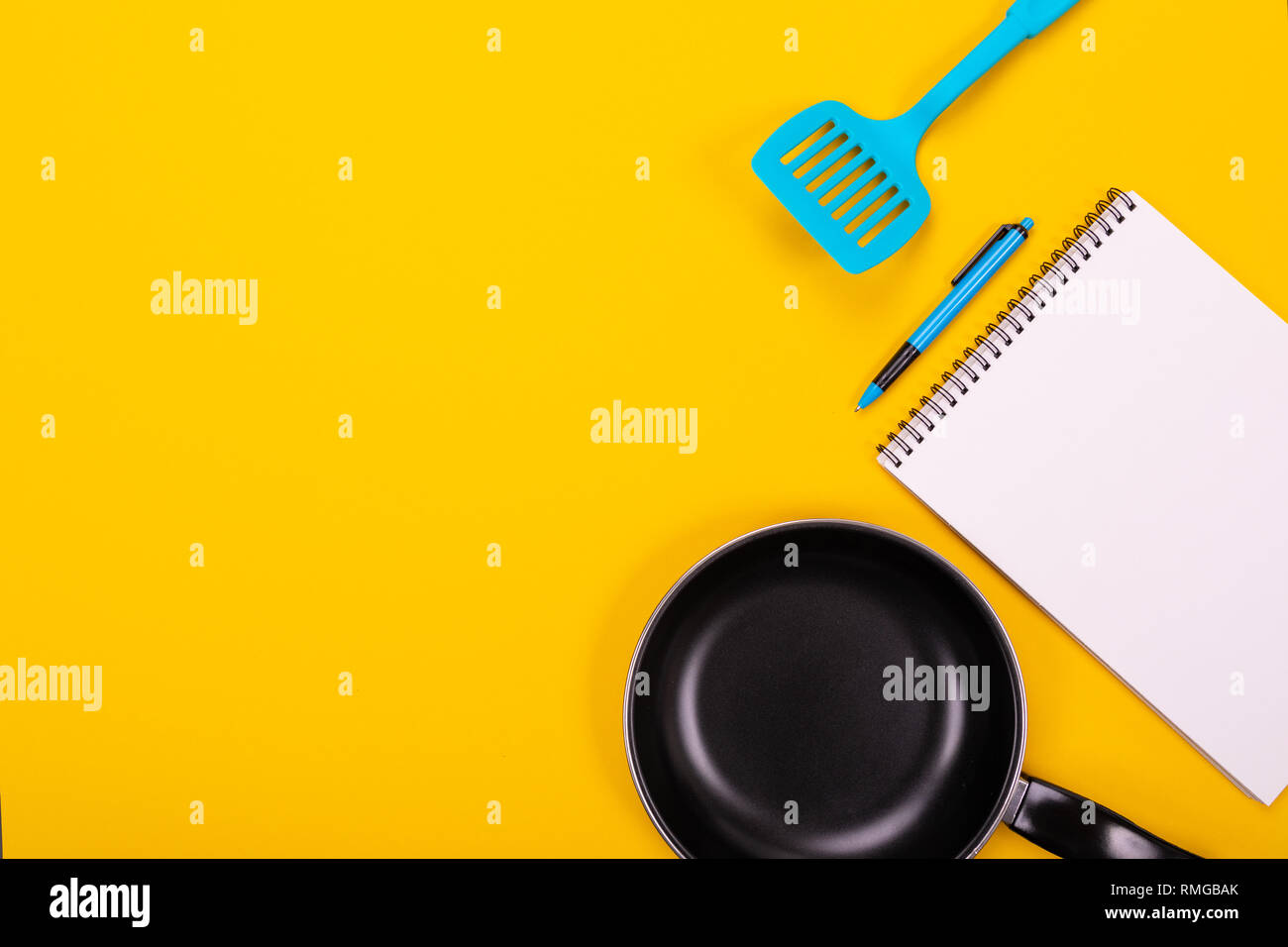 Kitchen utensils and clean sheet of paper isolated on yellow background ...